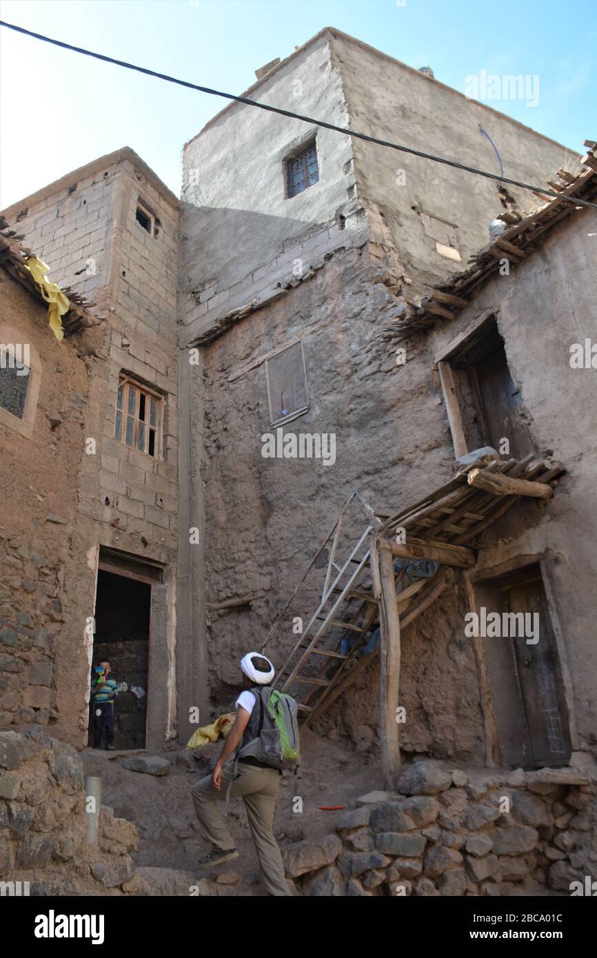 A tour guide approaches a home in a traditional village in the Ait ...