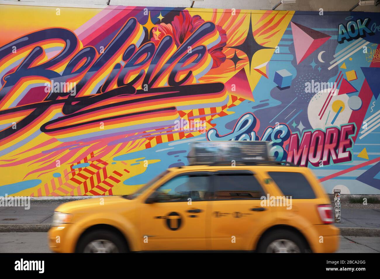 People walking past a mural painted by Queen Andrea entitled Believe on ...