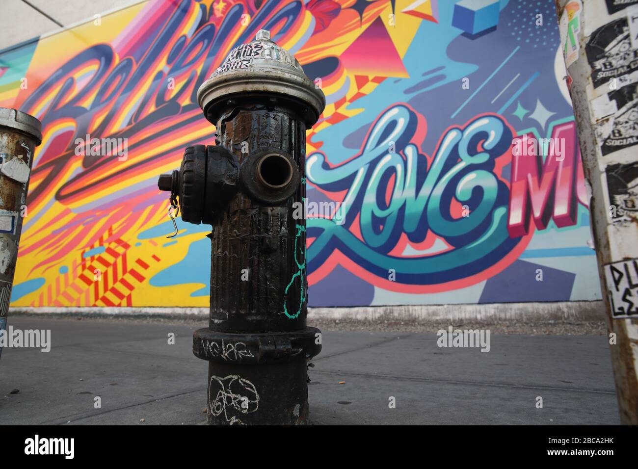 People walking past a mural painted by Queen Andrea entitled Believe on ...