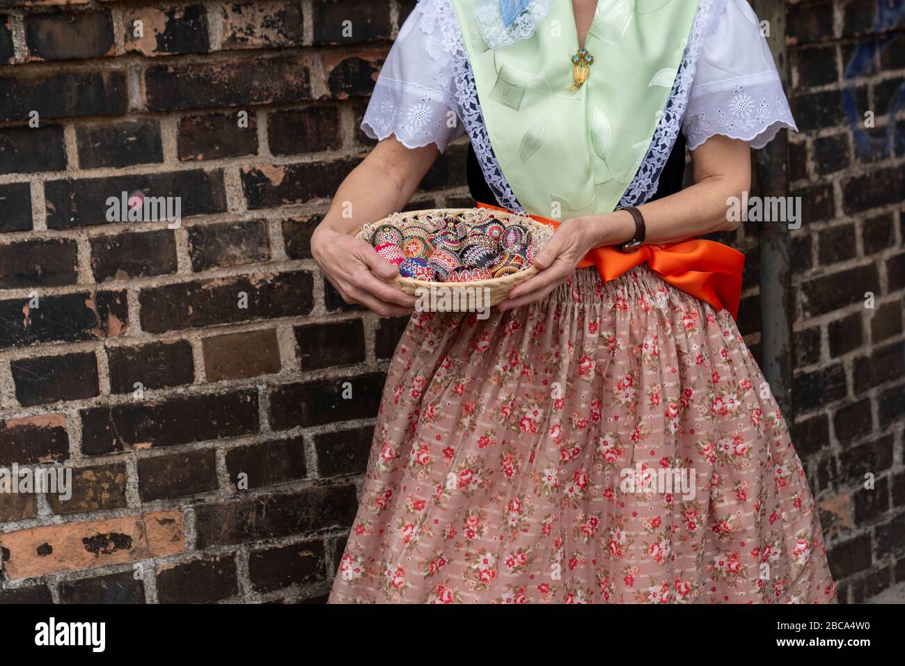 A woman is wearing the Sorbian costume, holding a basket with decorated ...