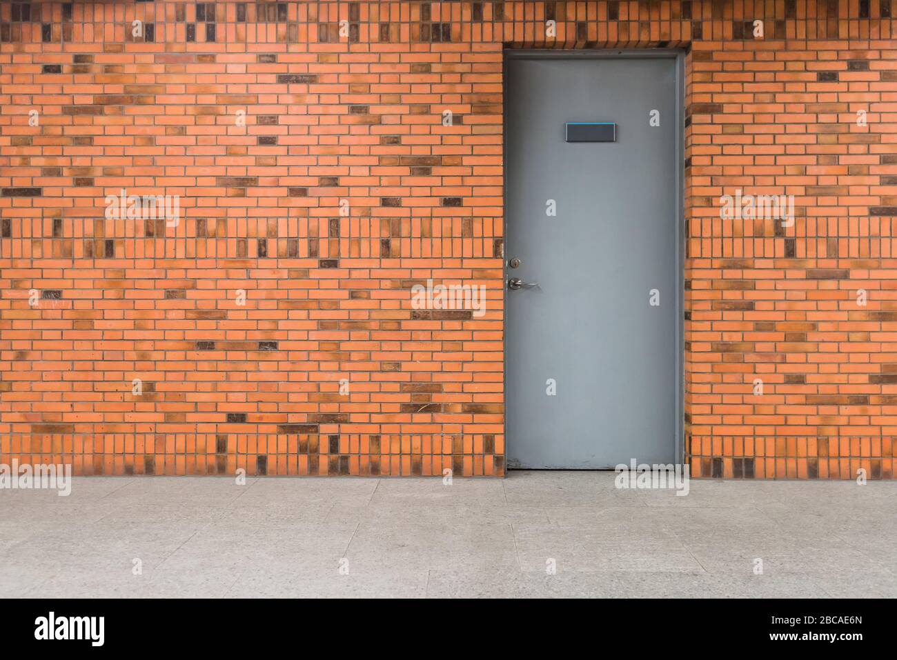 Red brick wall and closed door Stock Photo - Alamy