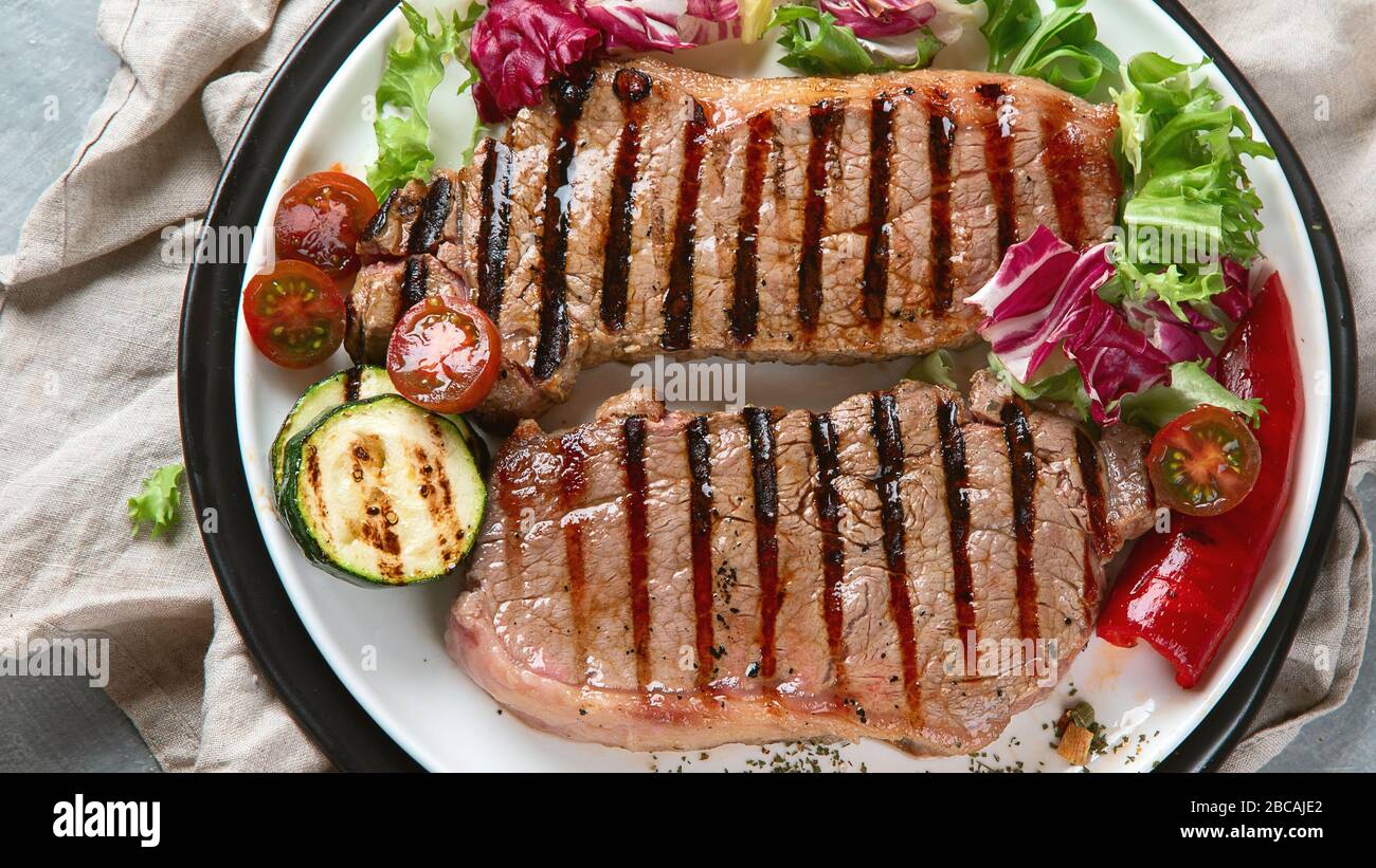 Grilled beef steaks with vegetables. top view Stock Photo - Alamy