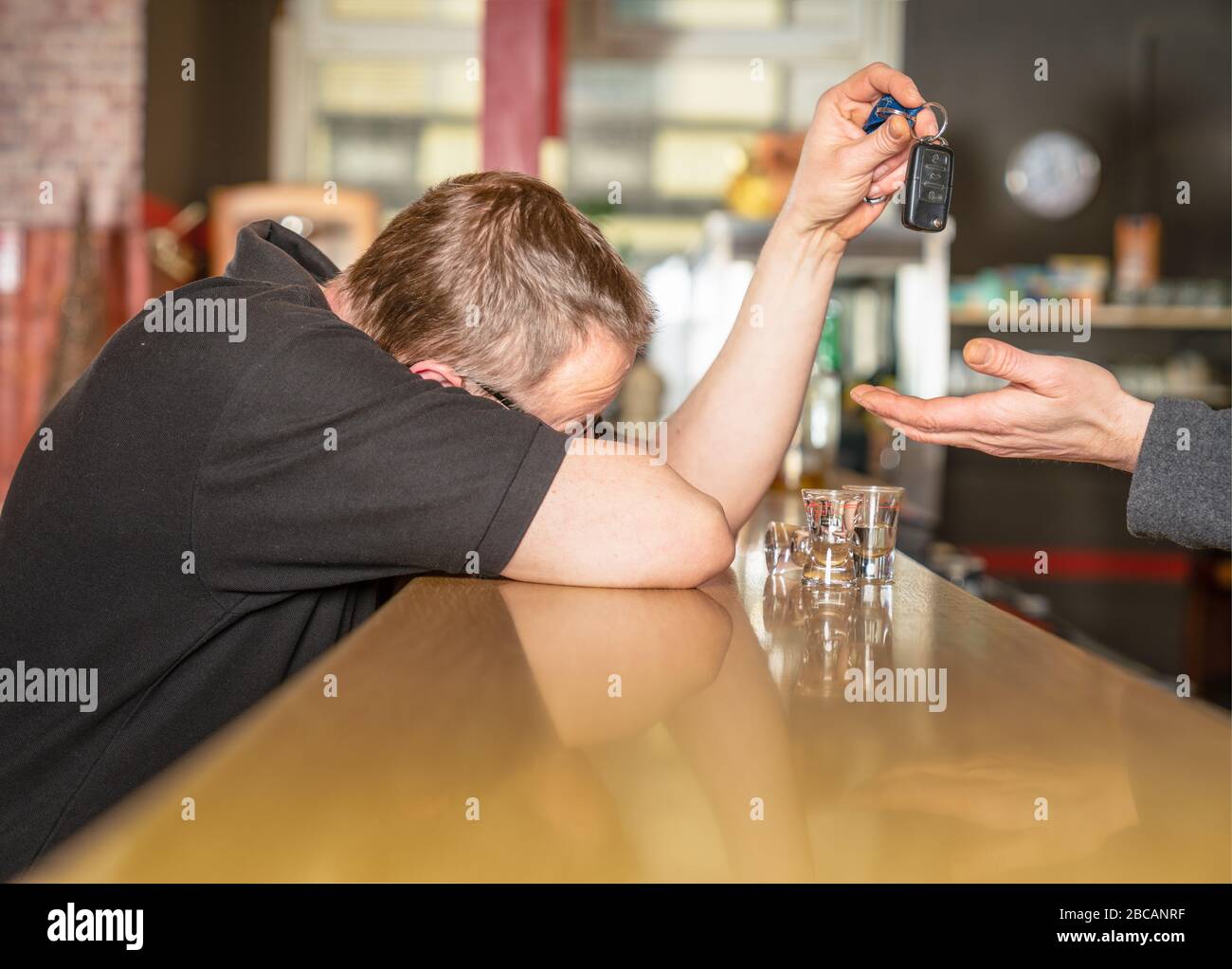 drunk man in a bar hands over his car key Stock Photo - Alamy