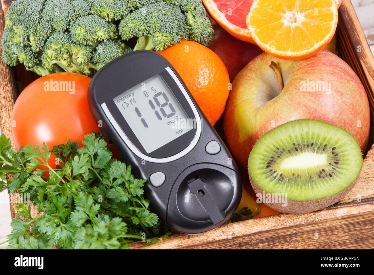 Glucose meter with natural healthy fruits and vegetables. Concept of ...