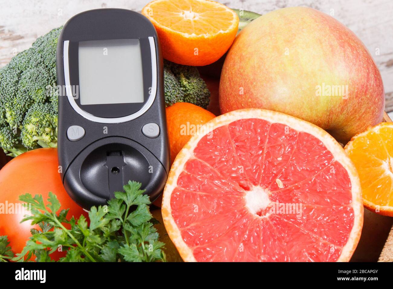Glucometer for measuring sugar level and natural fruits with vegetables ...