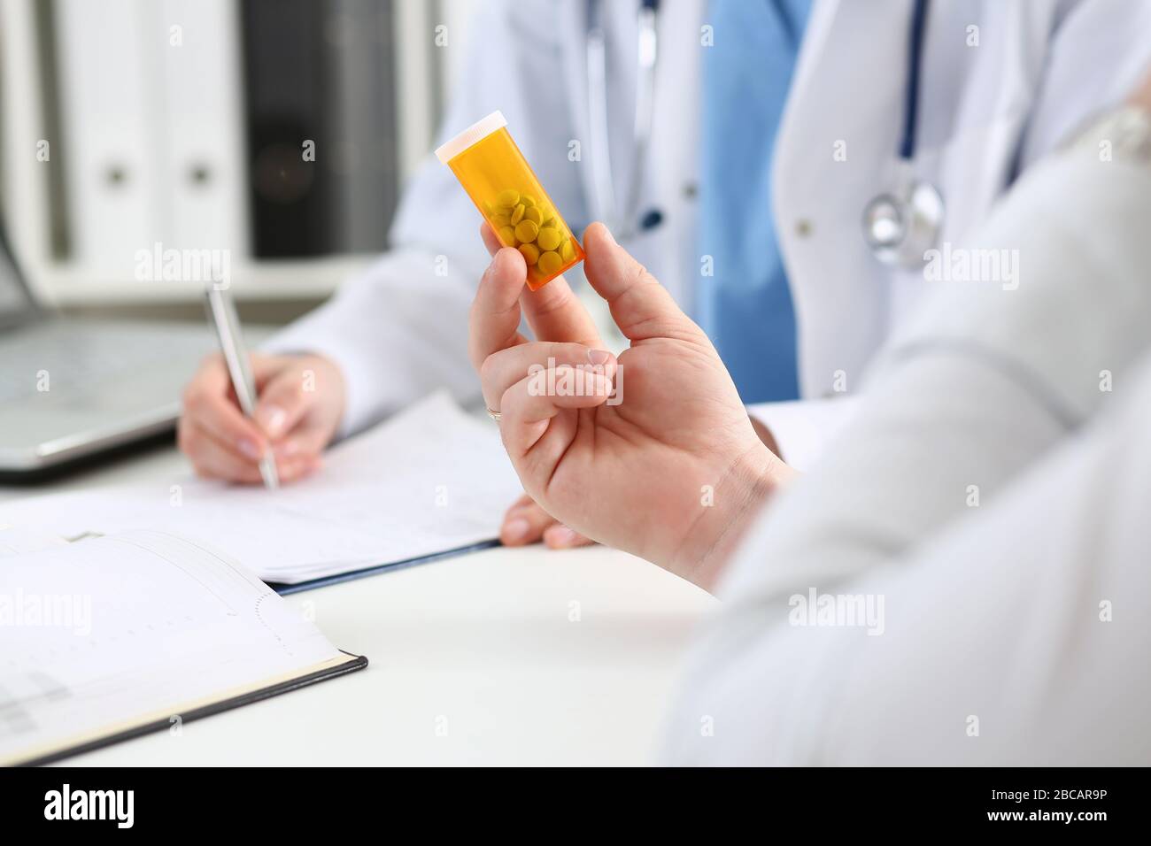 Female medicine doctor write prescription at worktable Stock Photo - Alamy