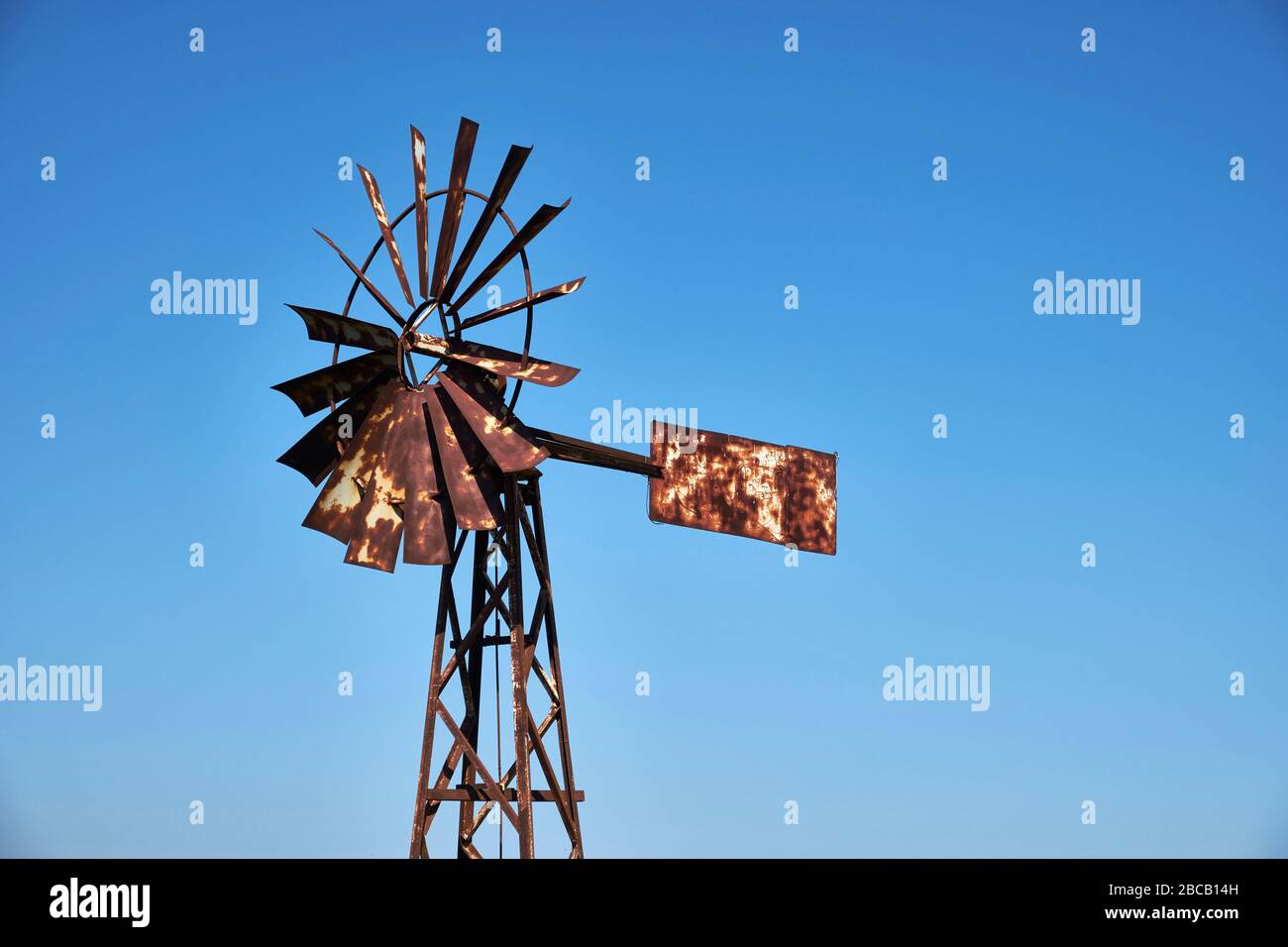 old rusty wind mill or wind pump opposite clear blue sky Stock Photo ...