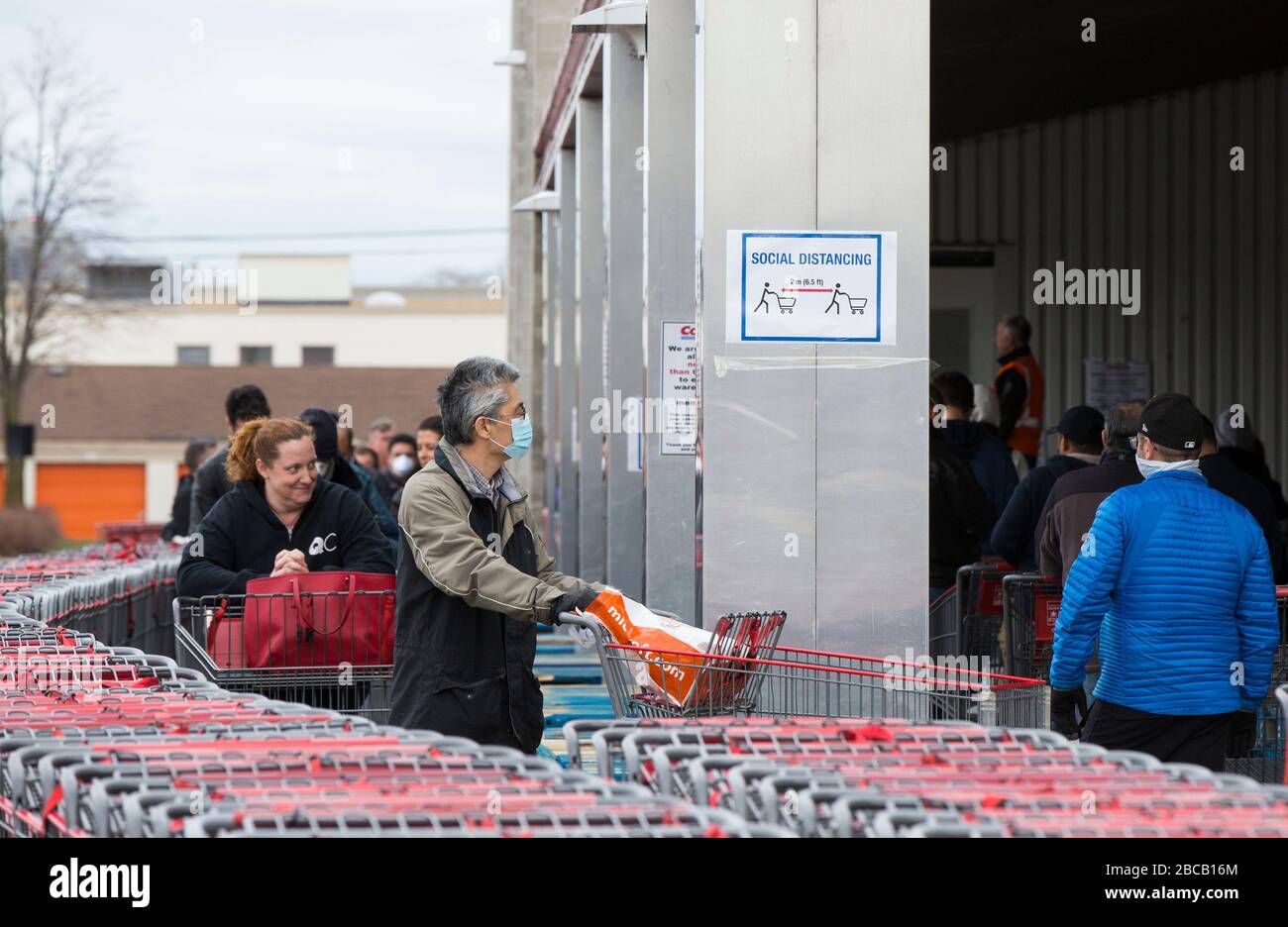Toronto, Canada. 3rd Apr, 2020. People line up with a social distance ...