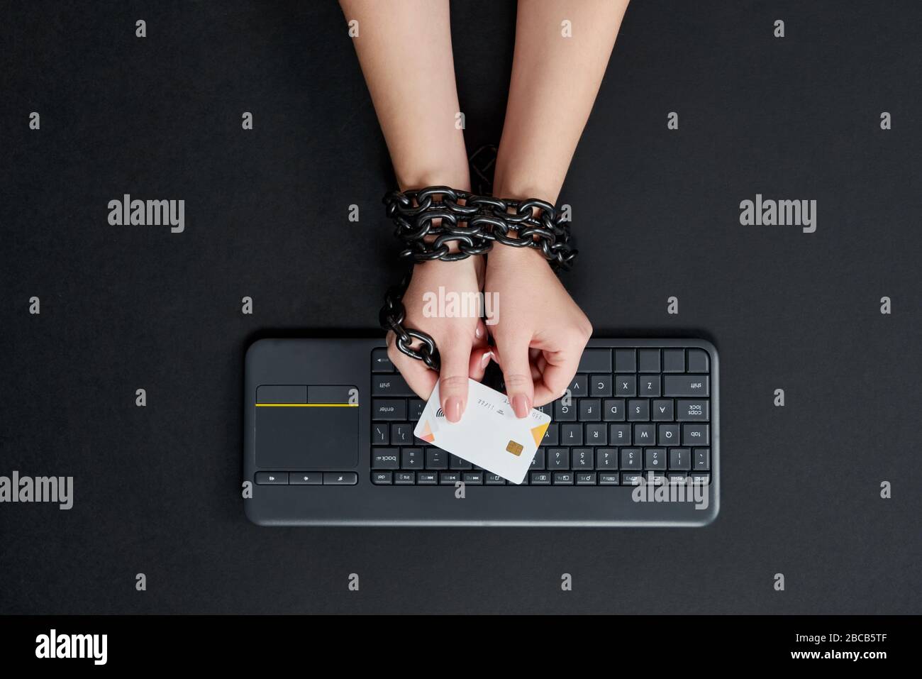 Woman with metal chain holding credit card over keyboard, online ...