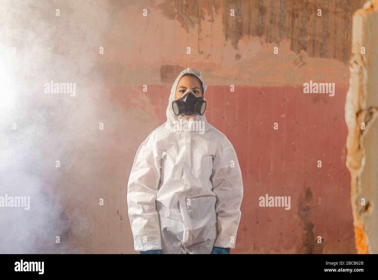 Young virologist doctor woman wearing a white biohazard protective suit ...