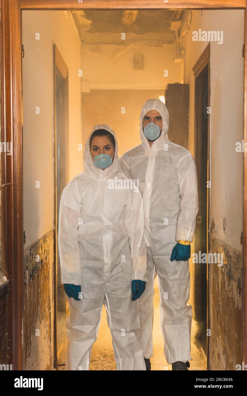 Couple of virologist doctors and scientists wearing biohazard ...