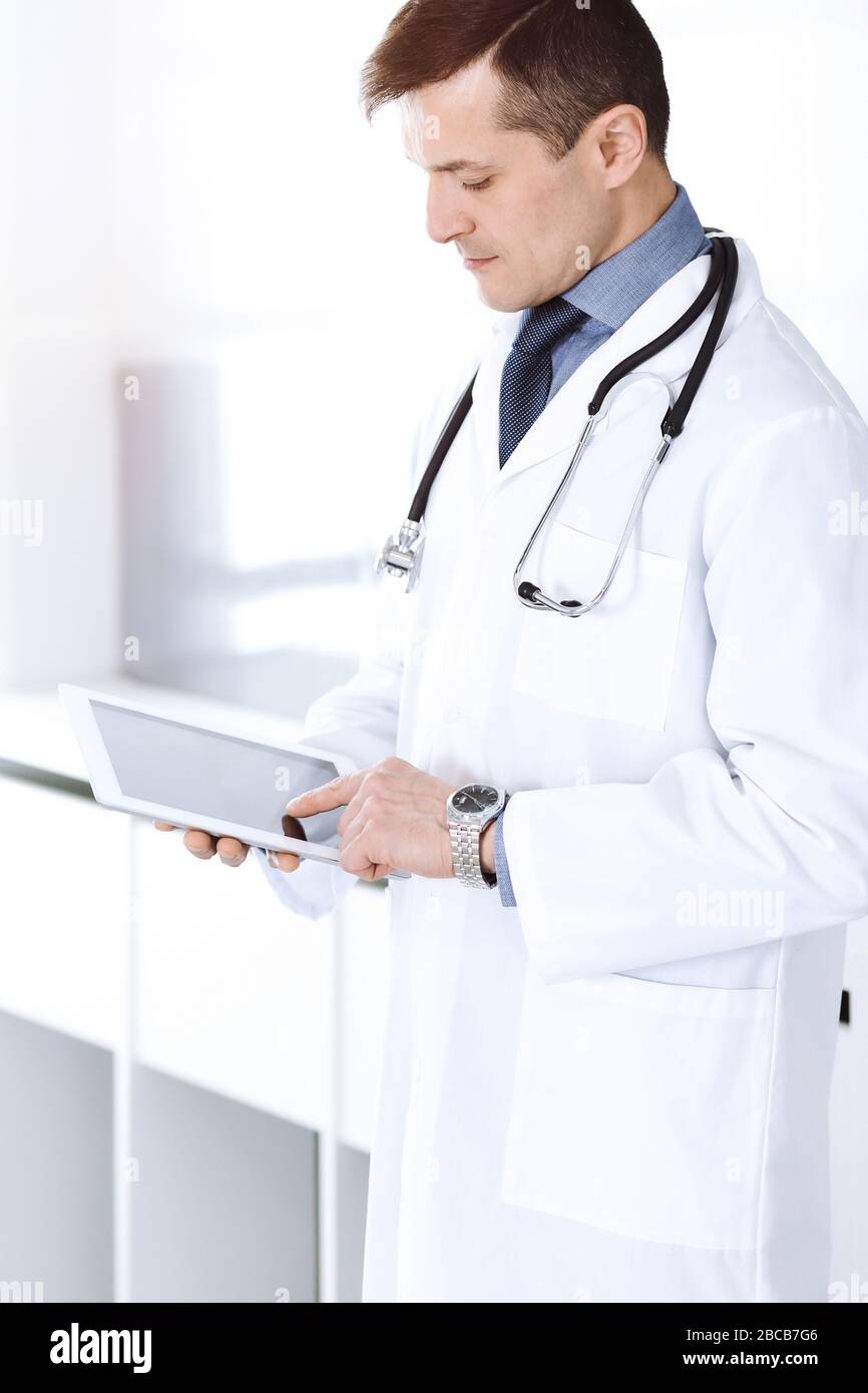 Doctor man using tablet computer for network research or virtual ...