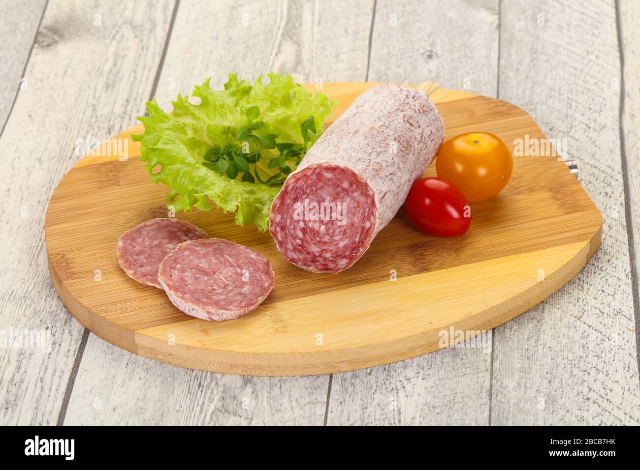 Italian dry Saliami pork sausage served salad leaves Stock Photo - Alamy