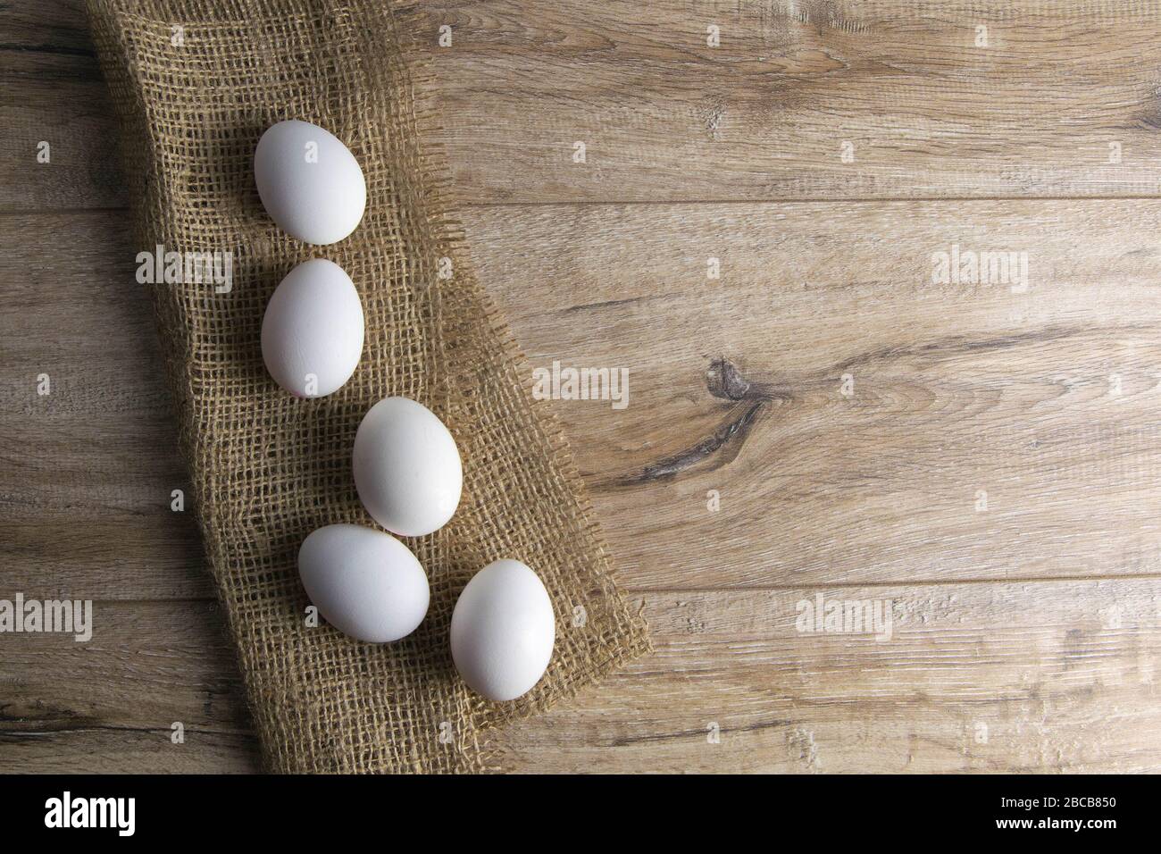 White and quail eggs stand on a burlap on a wooden table Stock Photo ...