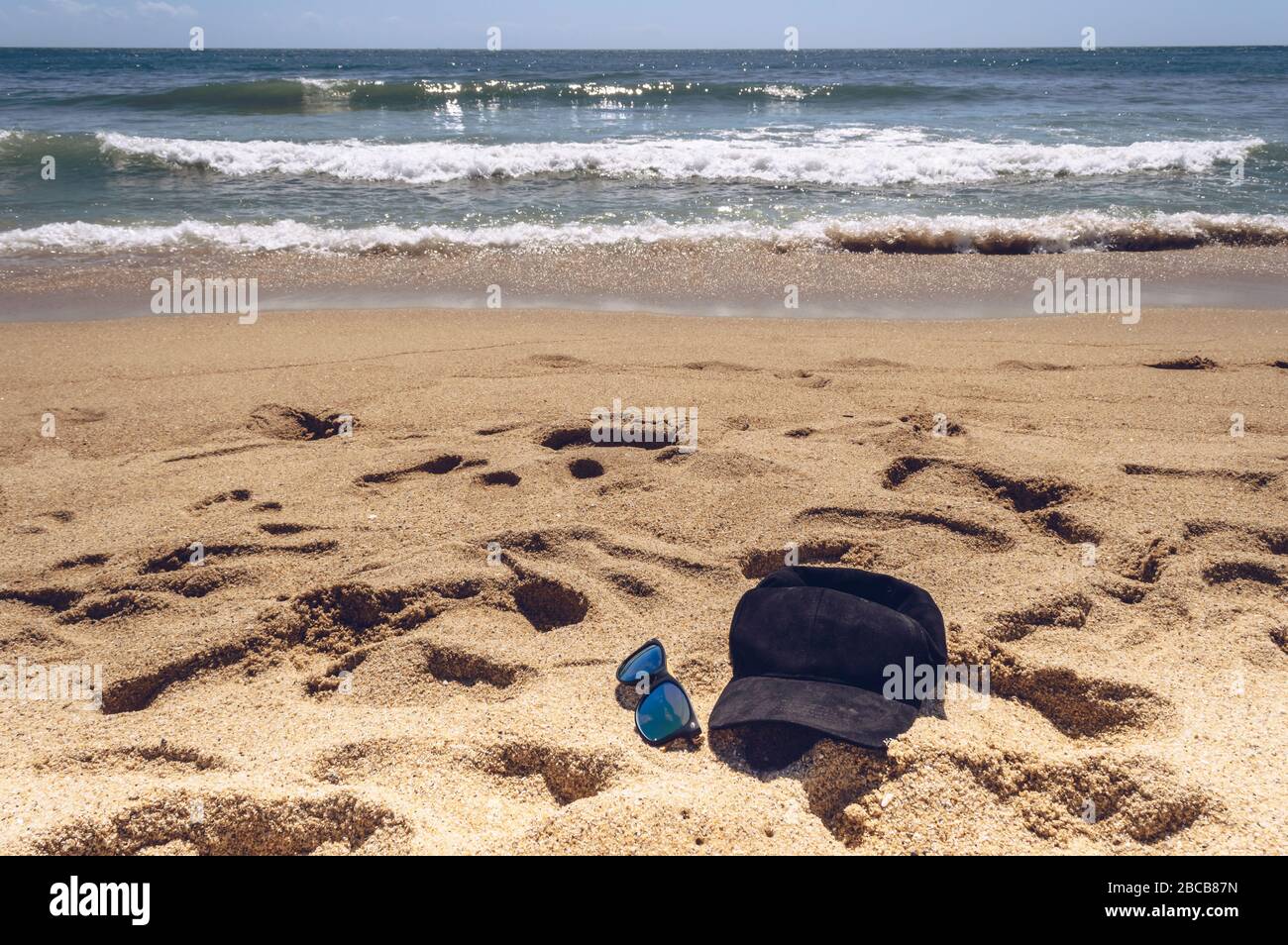 baseball cap and sunglasses on the beach on sunny day Stock Photo - Alamy