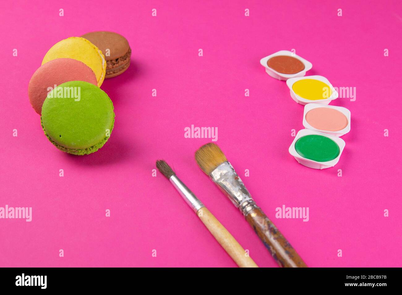 Makarons on a pink background are next to the colors of macaroons and ...