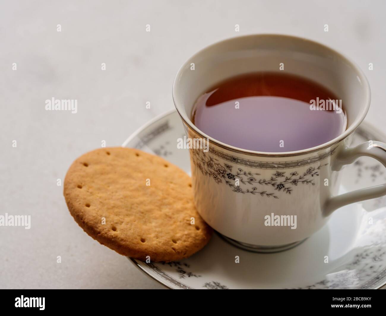 Close up of English tea in a fine porcelain china cup with a digestive ...