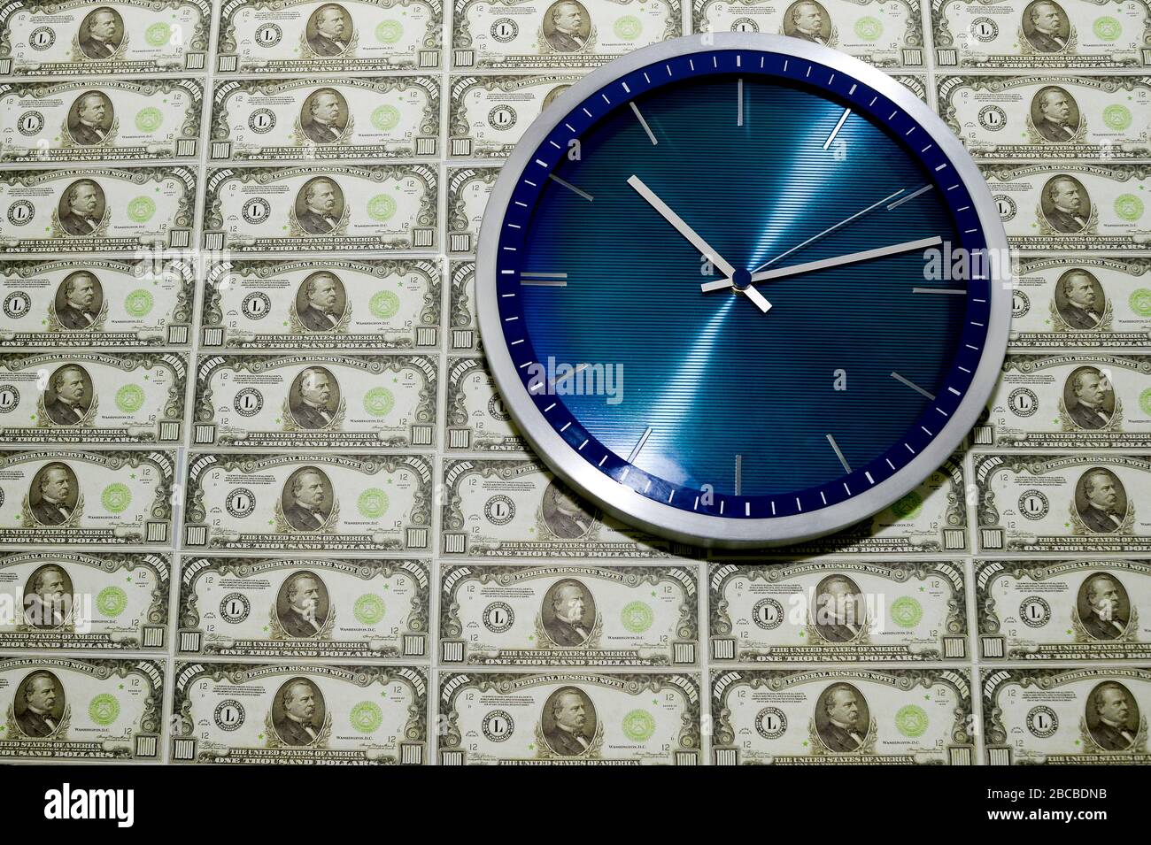 The concept of time is money, a wall clock against a pile of thousand ...