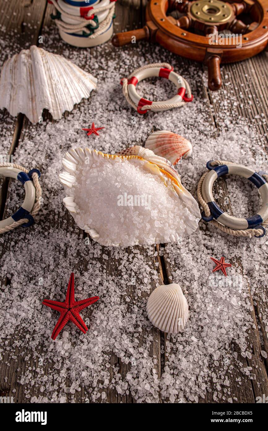 Pile of sea salt in shell on wooden background Stock Photo - Alamy