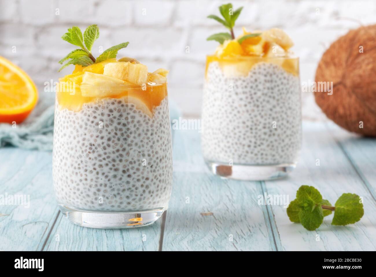Chia pudding with banana in two glass glasses with raw chia seeds on a ...