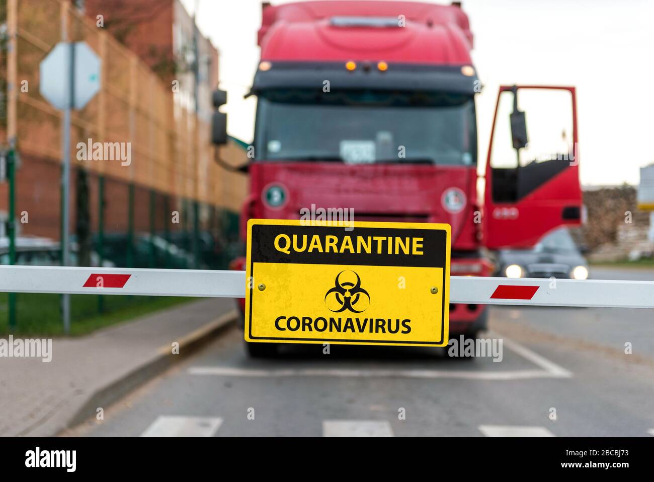 Truck standing at the barrier with a virus warning sign, Coronavirus ...