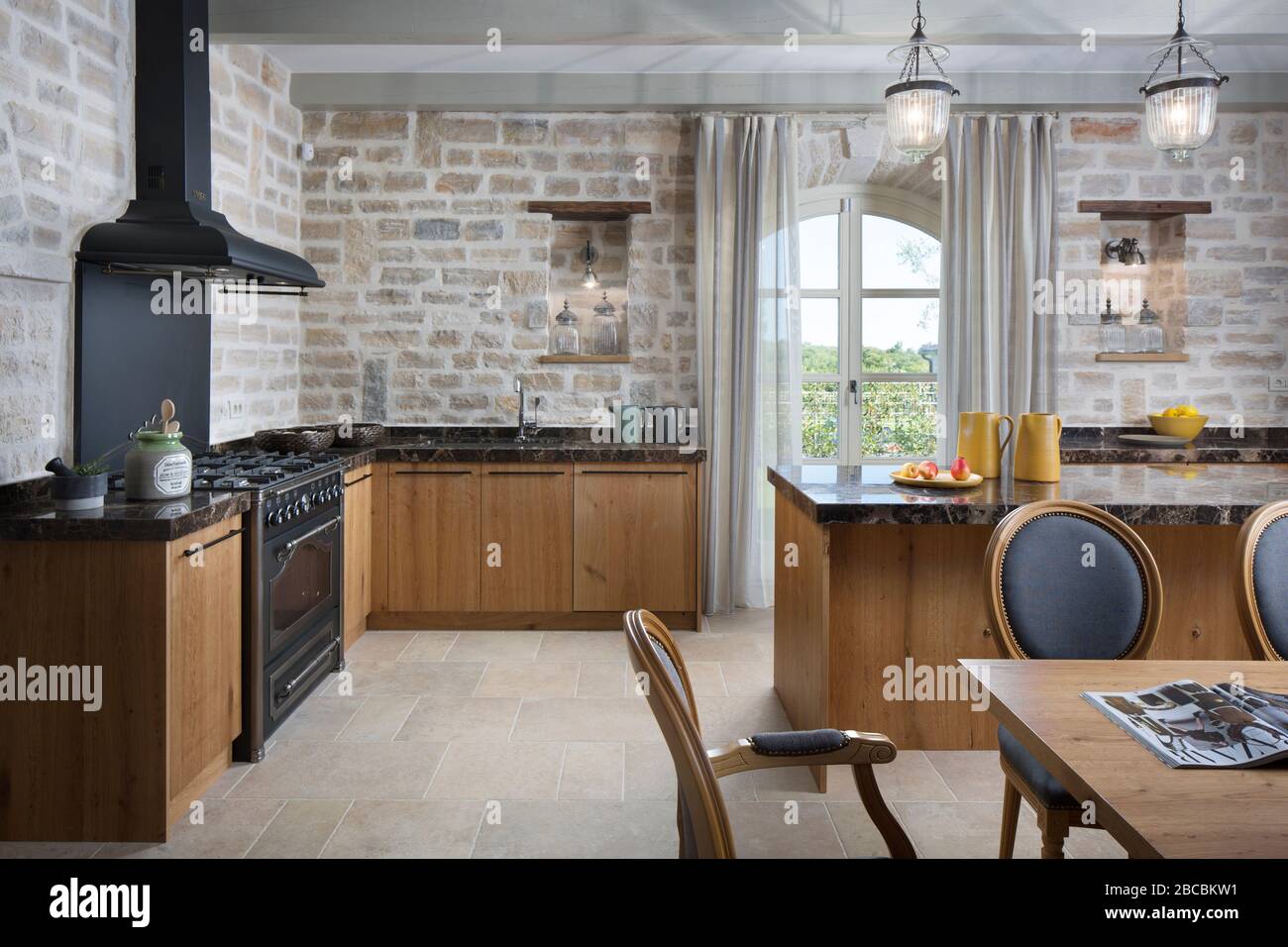 Classic style stone interior with large wooden kitchen Stock Photo - Alamy