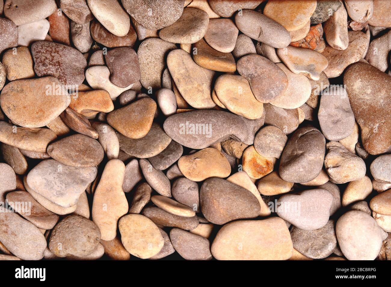 brown rounded stones of heterogeneous structure, background Stock Photo ...