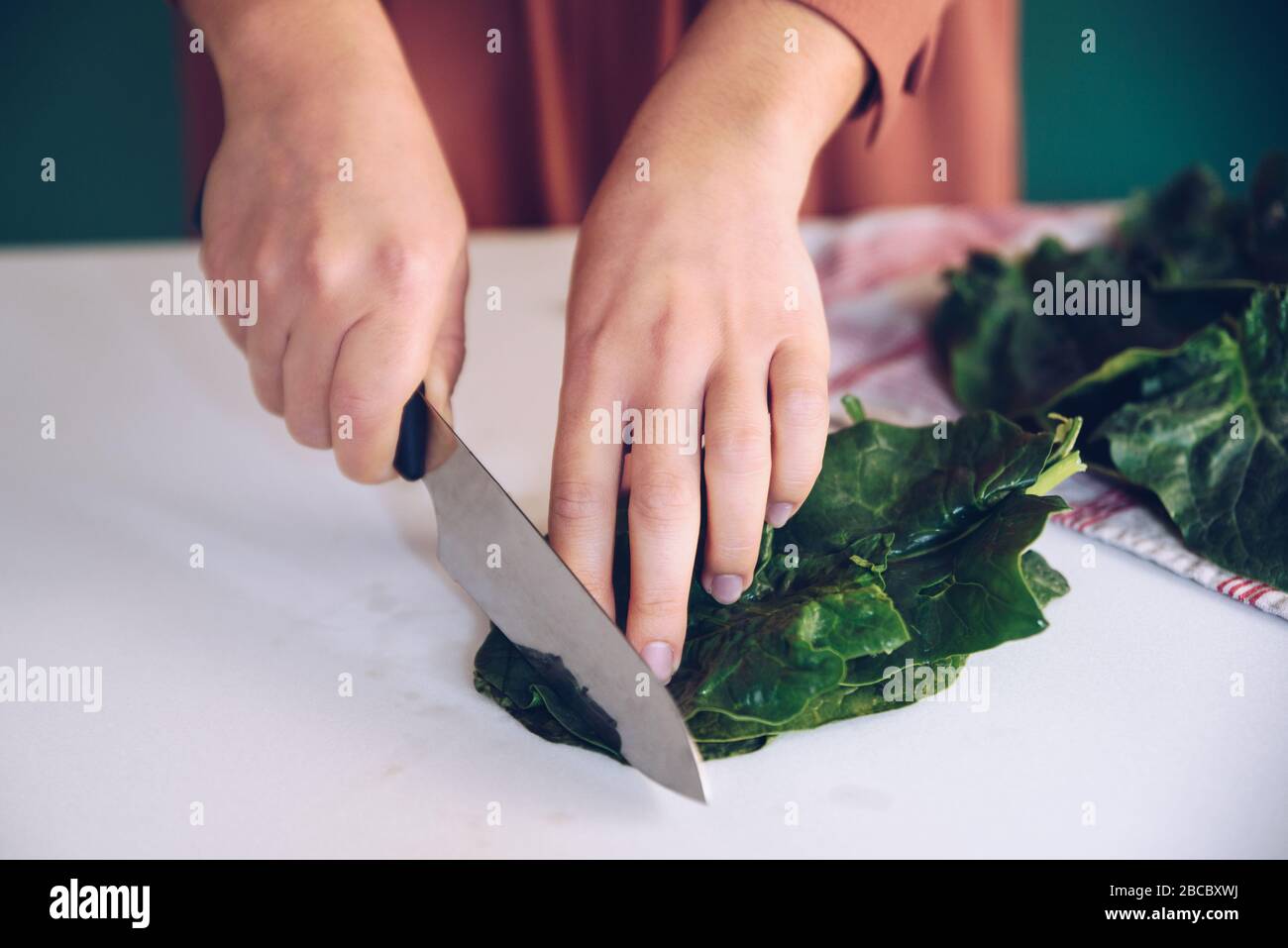 Woman cutting spinach on the marble at her kitchen Stock Photo - Alamy