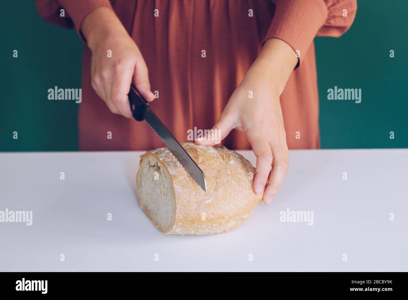 Woman cutting bread at kitchen Stock Photo - Alamy