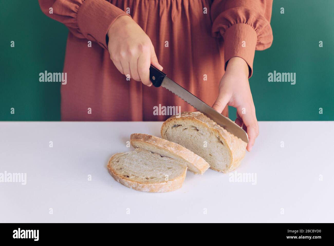 Woman cutting bread at kitchen Stock Photo - Alamy