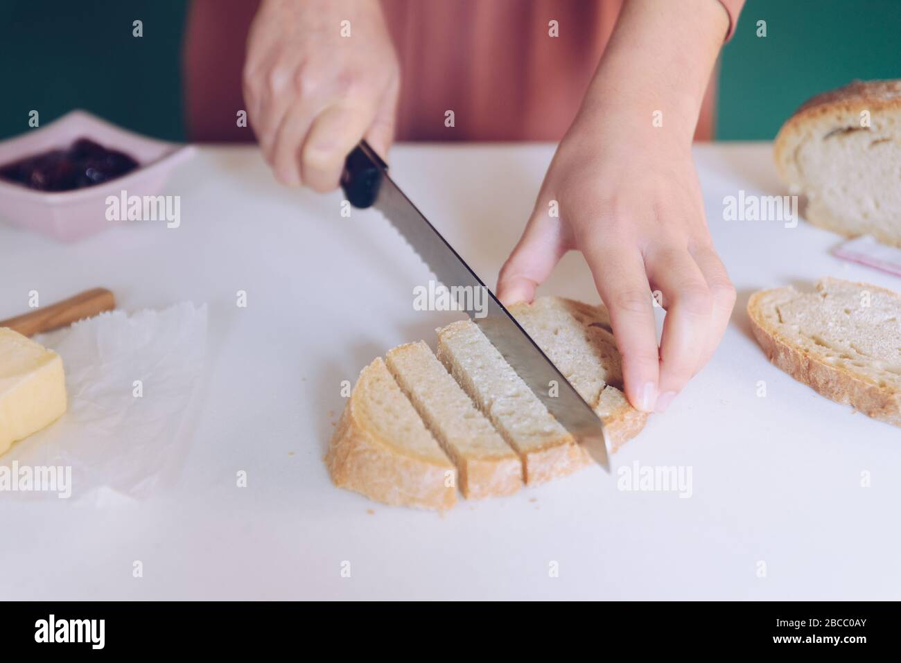 Woman cutting bread at kitchen Stock Photo - Alamy