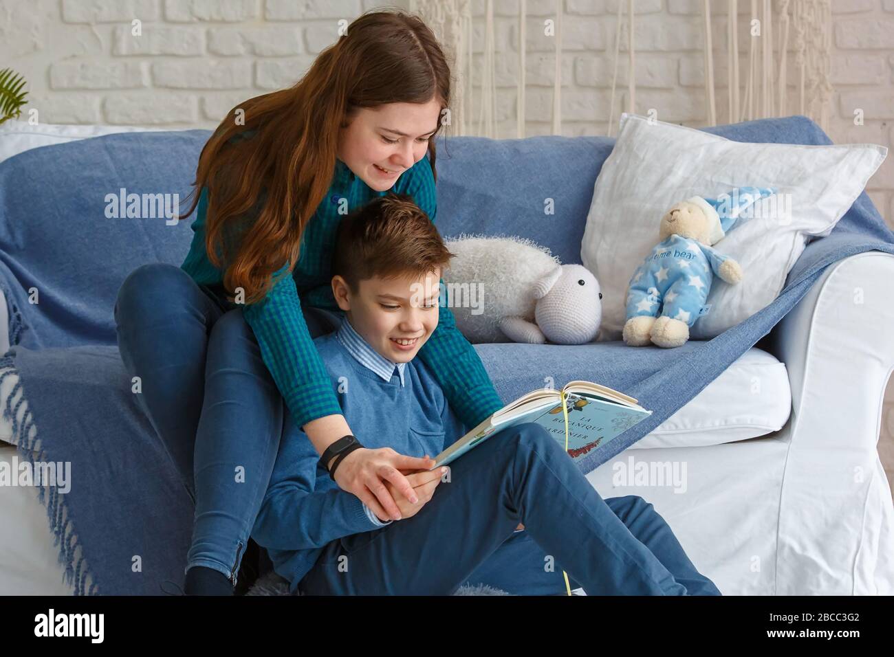 Brother And Sister Are Reading A Book We Remain At Home In Quarantine