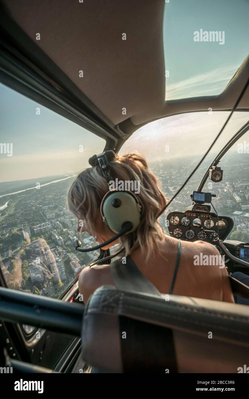 Portrait of beautiful blonde women enjoying helicopter flight. She is ...