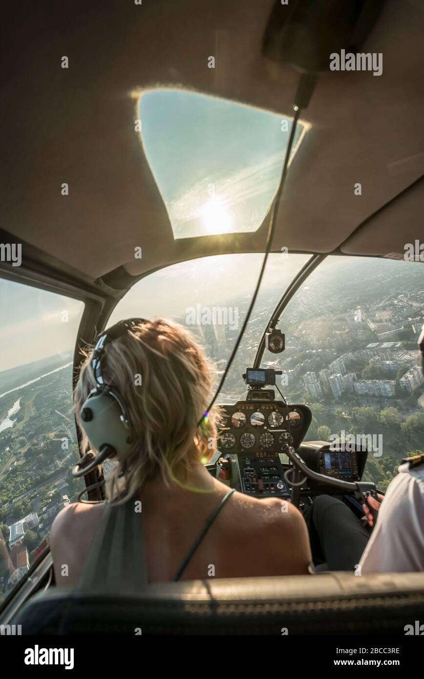 Portrait of beautiful blonde women enjoying helicopter flight. She is ...