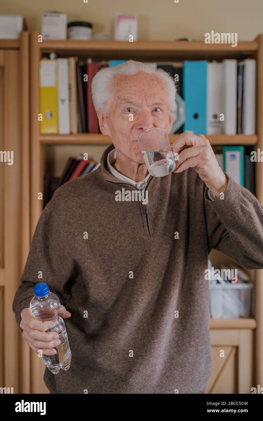 Smiling Old man drinking water. Caring for good hydration during ...