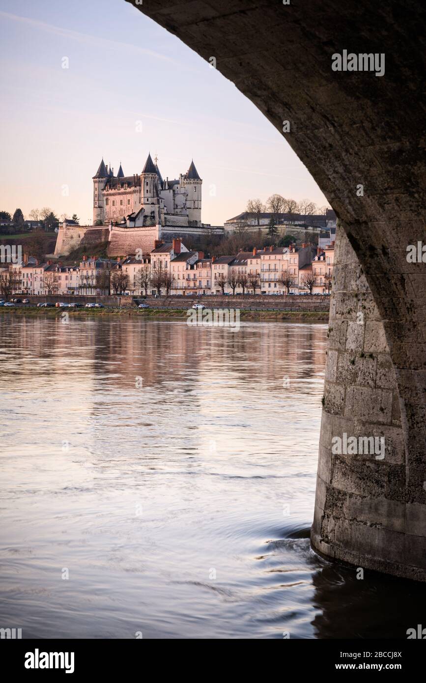 Panorama of Saumur skyline under a bridge arch with medieval castle and ...