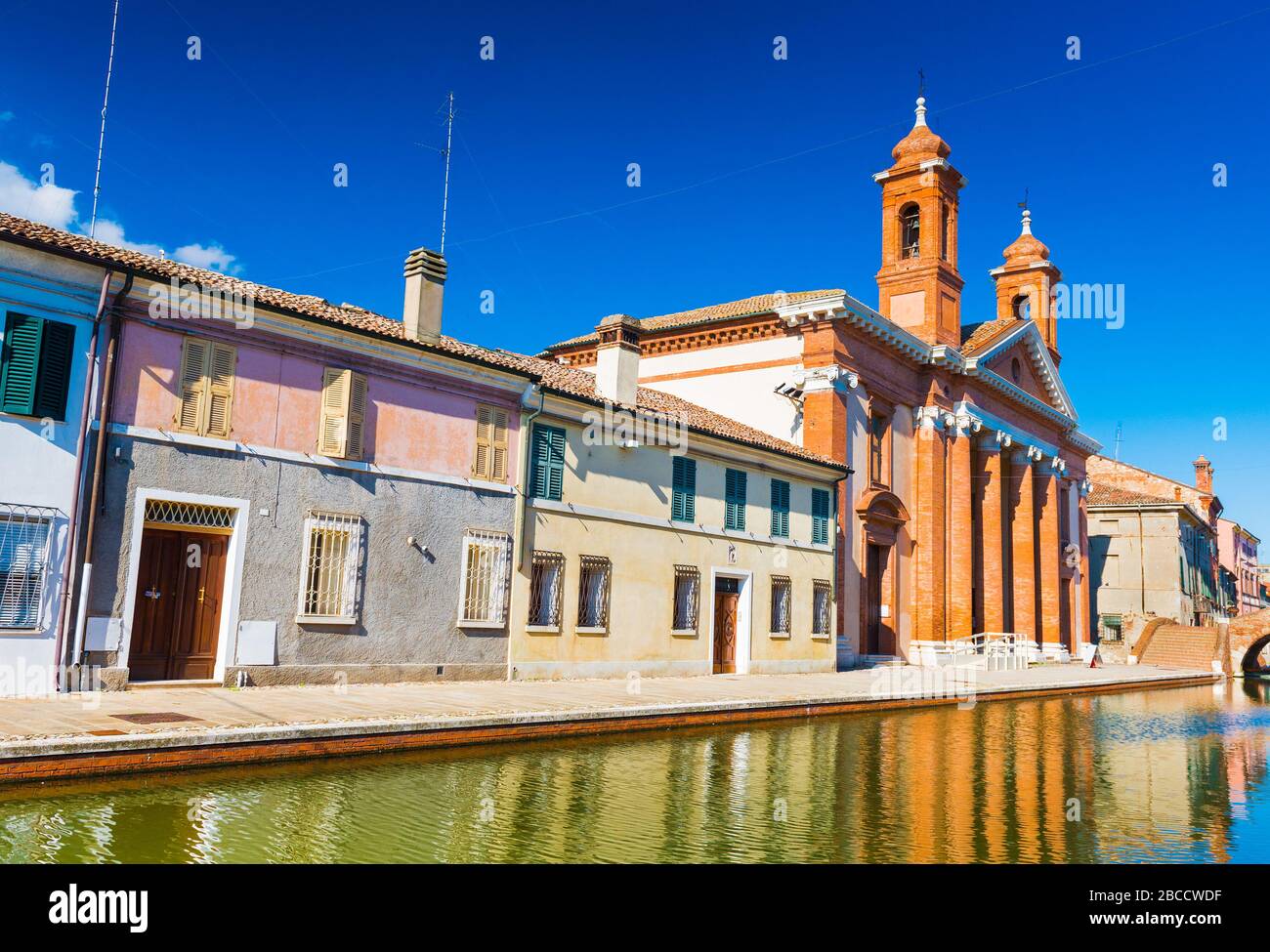 View of the street with canal and colored houses in a small Italian ...