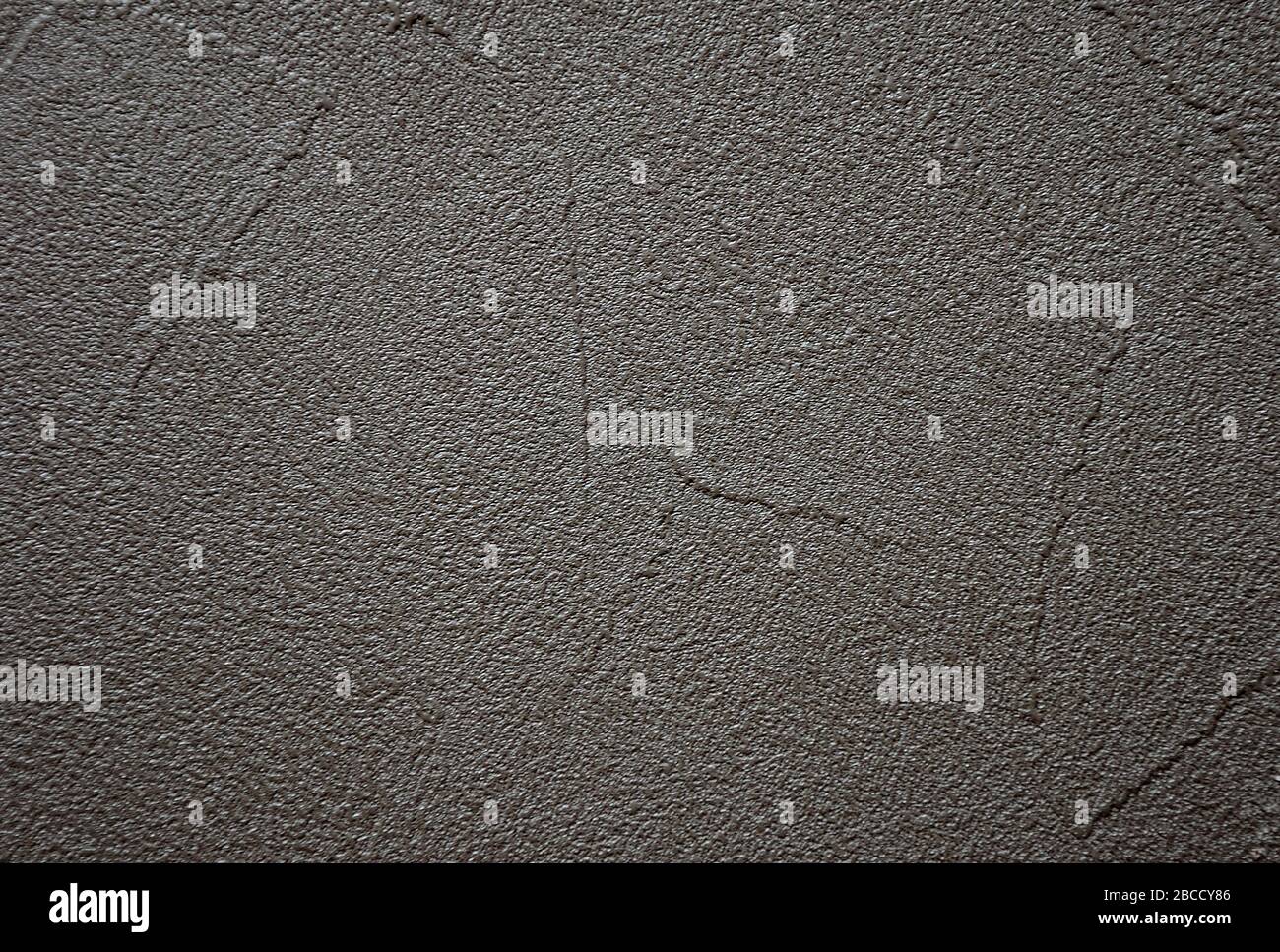 The wall is covered with decorative plaster painted in dark gray. Close ...