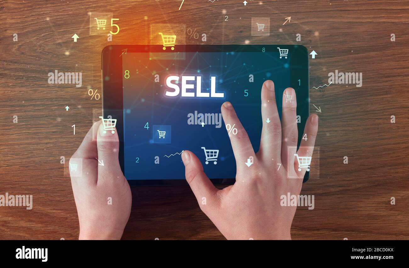Close-up of a hand holding tablet with SELL inscription, online ...