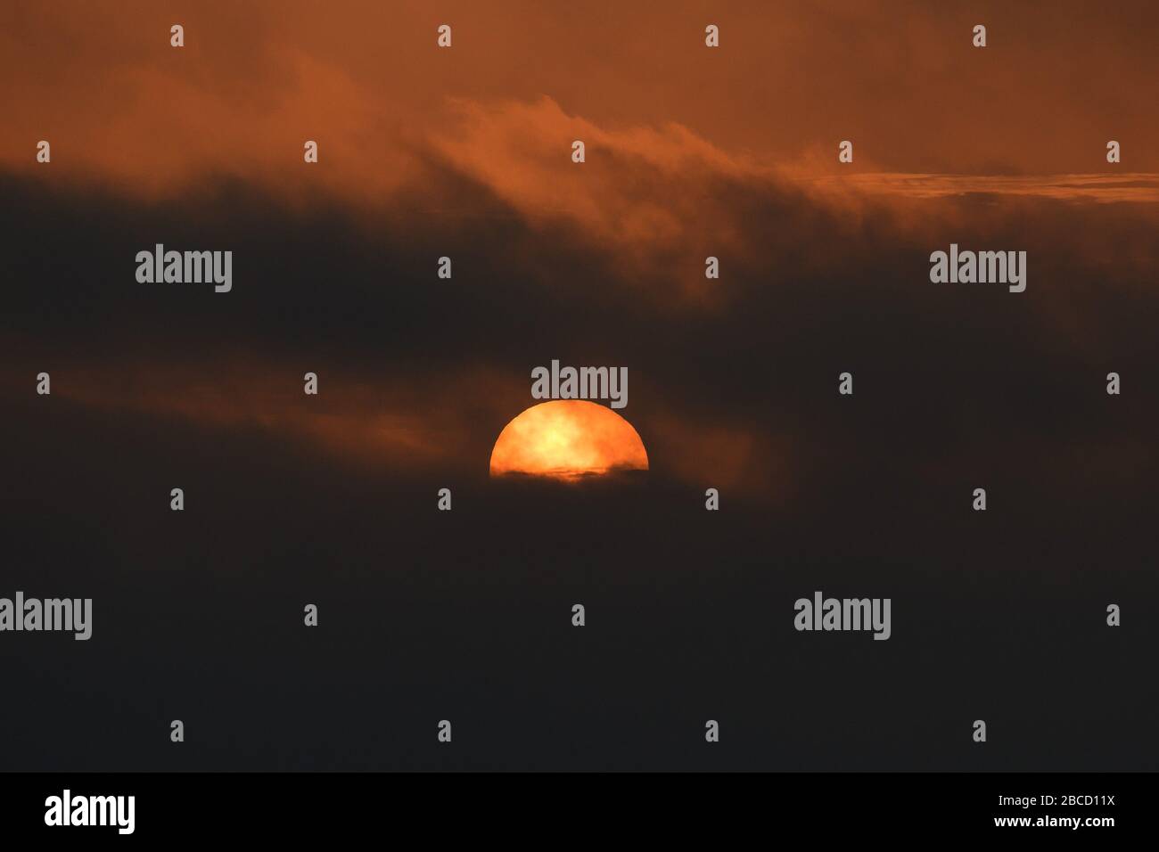 Big colorful setting sun in the clouds in Peru Stock Photo - Alamy