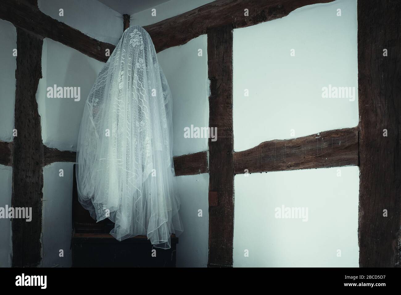 A spooky ghost floating above a metal box in a corner of an old timber ...