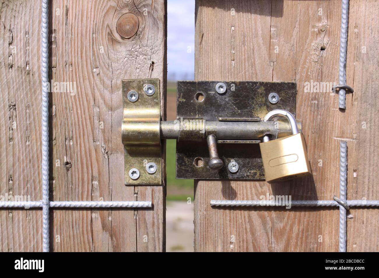 closed wooden gate with metal padlock on it forbidden access from a ...
