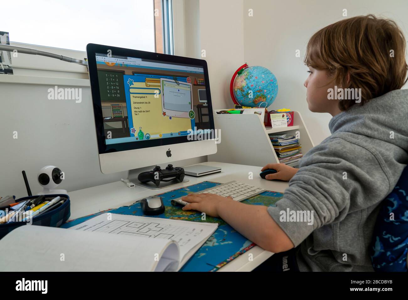 Young boy, primary school children, home learning, doing schoolwork ...