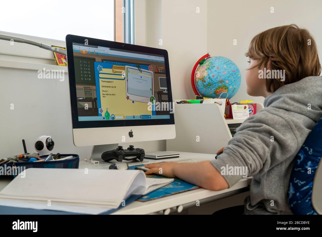 Young boy, primary school children, home learning, doing schoolwork ...