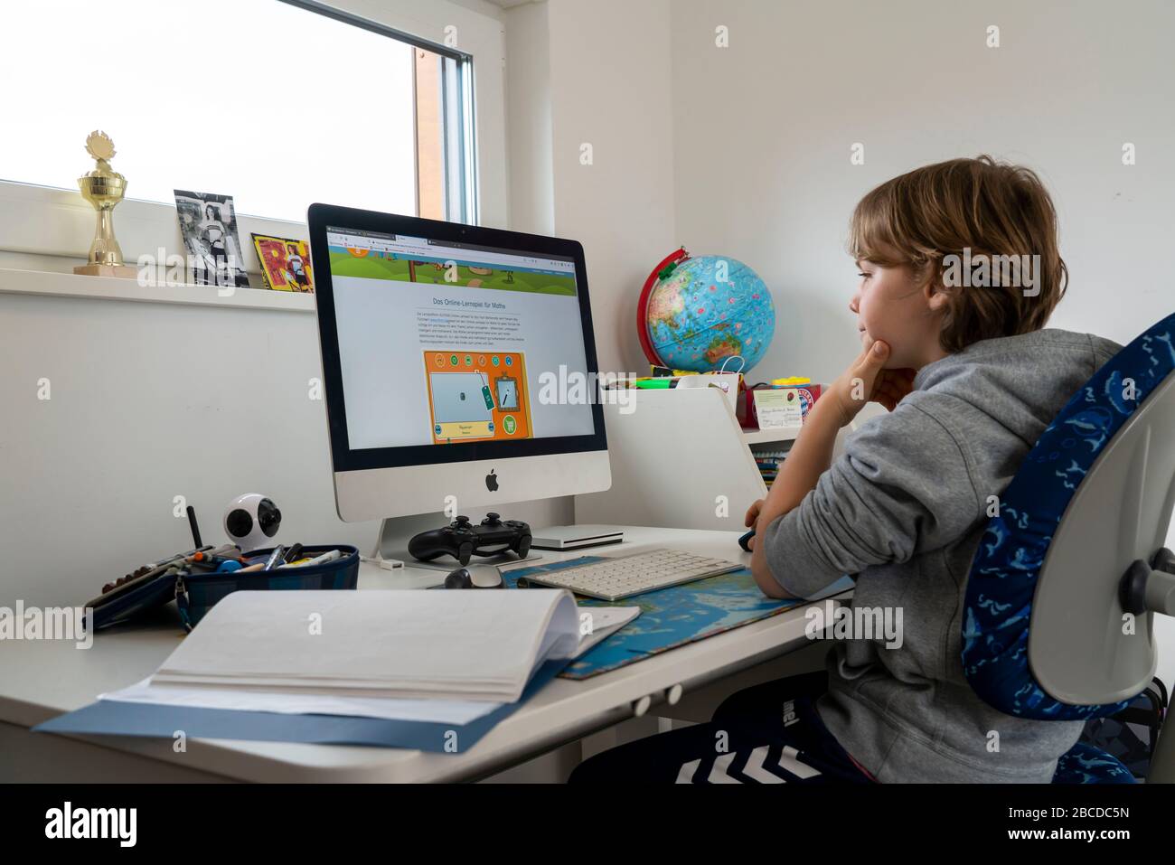 Young boy, primary school children, home learning, doing schoolwork ...