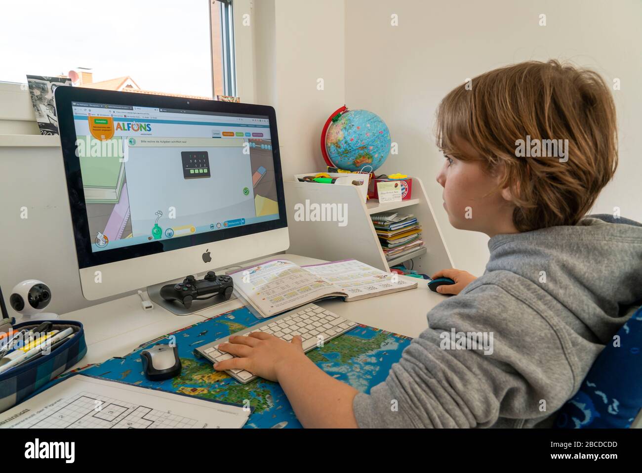 Young boy, primary school children, home learning, doing schoolwork ...