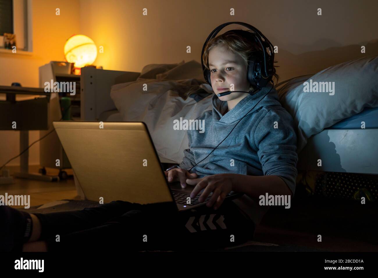 Boy, at home at the computer, laptop, in the children's room, playing a ...