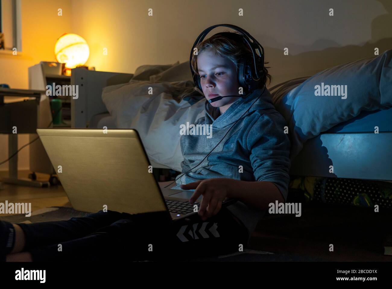 Boy, at home at the computer, laptop, in the children's room, playing a ...