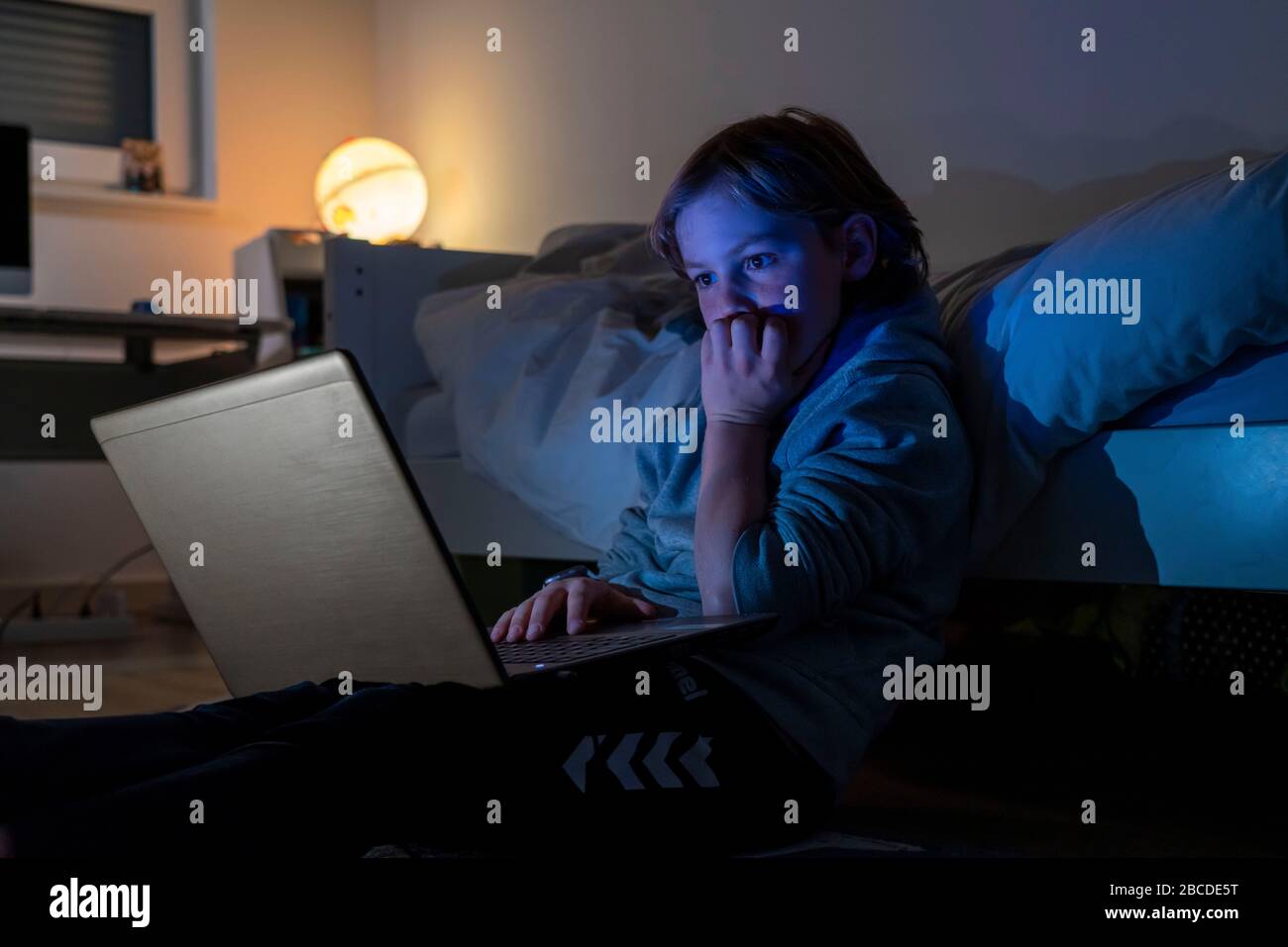 Boy, at home on the computer, laptop, in the kids' room, playing a game ...