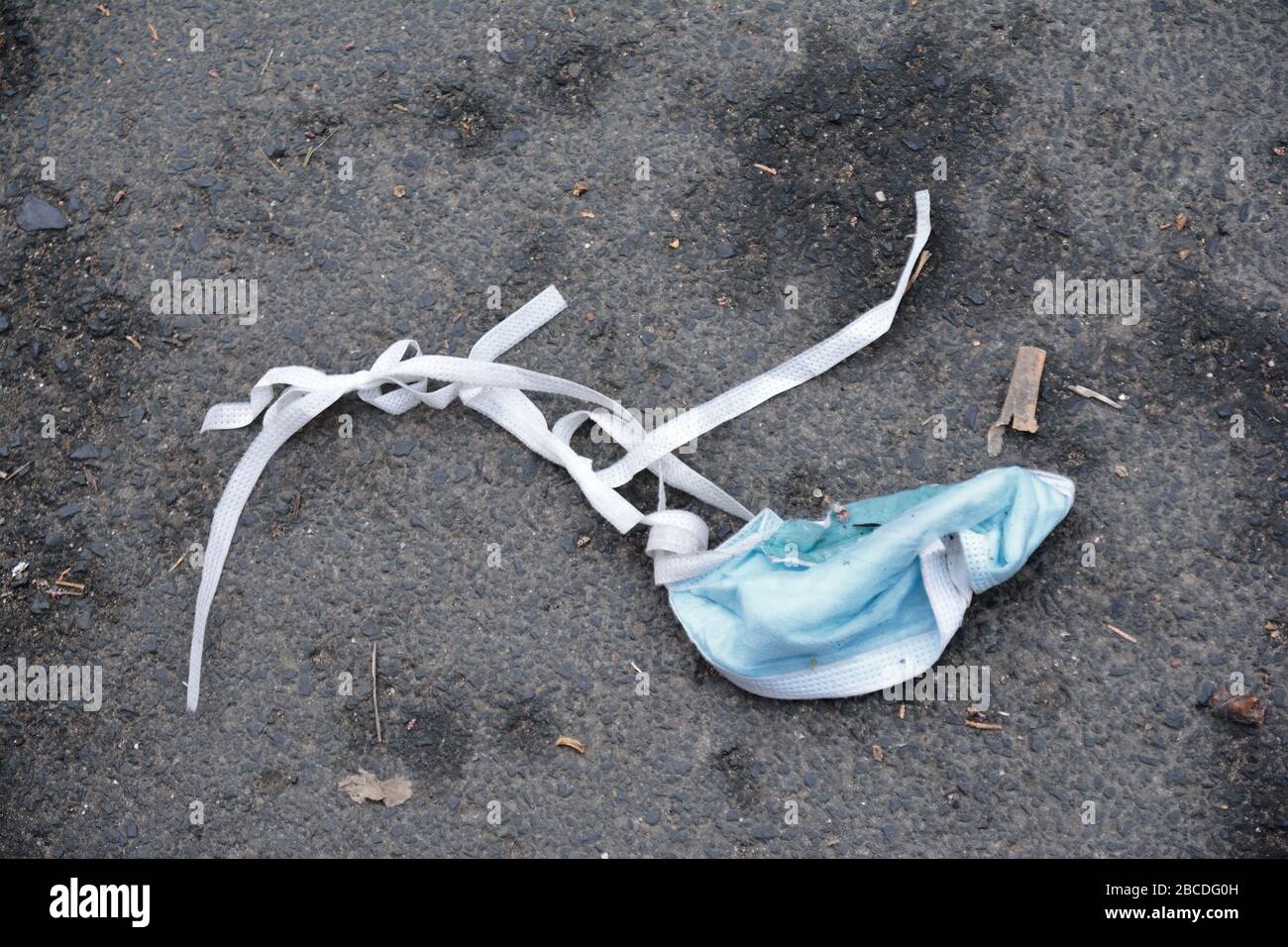 A discarded surgical face mask lying in the street Stock Photo - Alamy